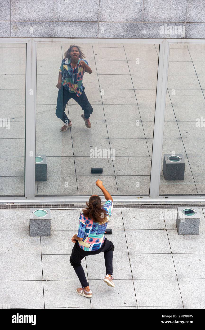 High angle view of a dancing young woman reflecting and looking at ...