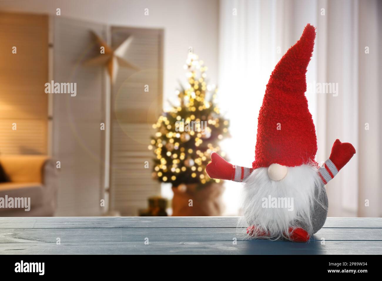 Funny Christmas gnome on blue wooden table in room with festive ...