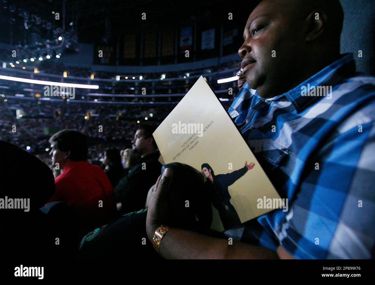 A spectator holds onto a program during the Michael Jackson public ...
