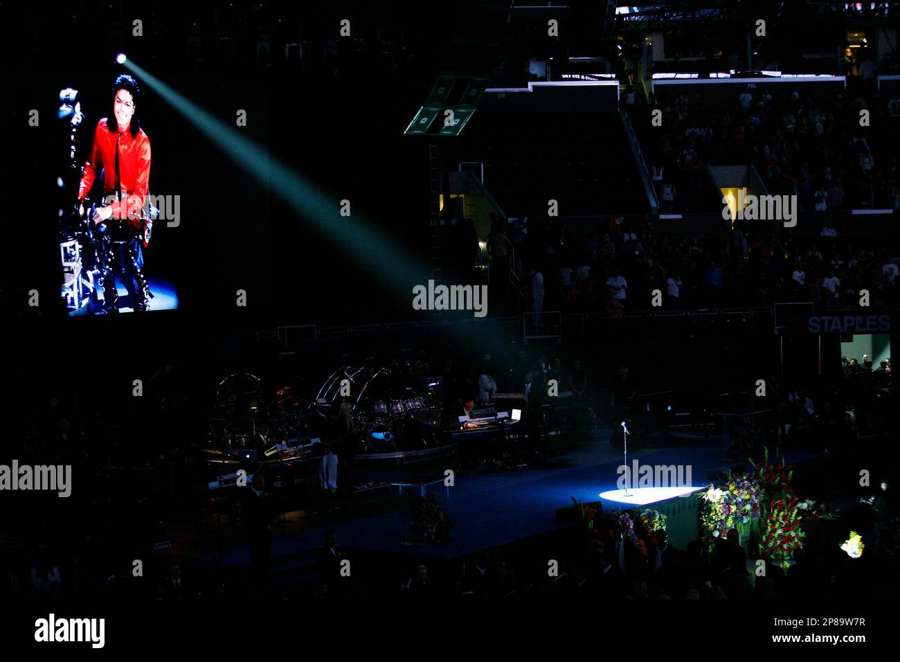 Michael Jackson's photograph is projected as a spotlight illuminates a ...