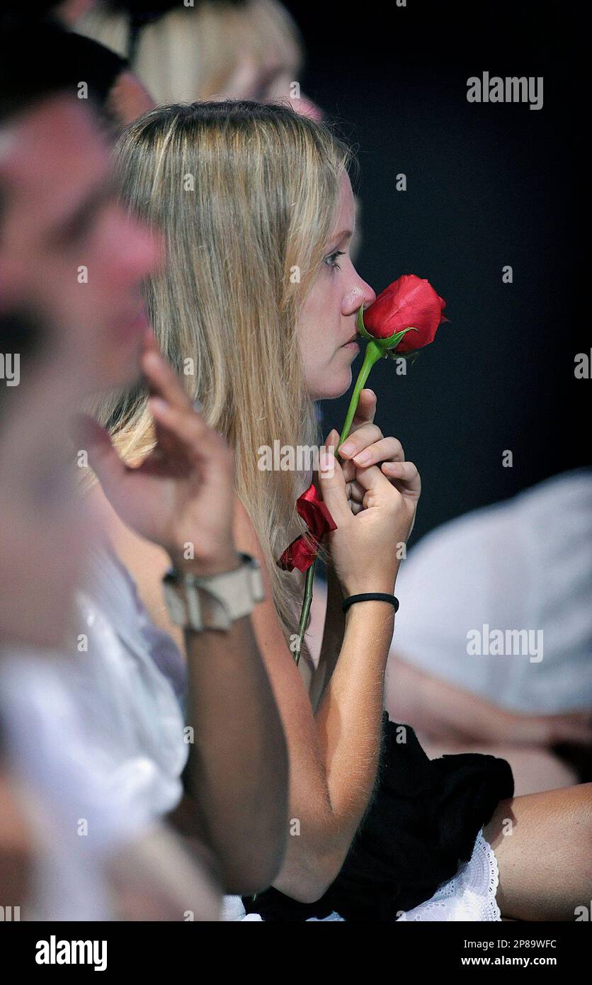 A fan holds a single rose as she watches performances during Michael ...