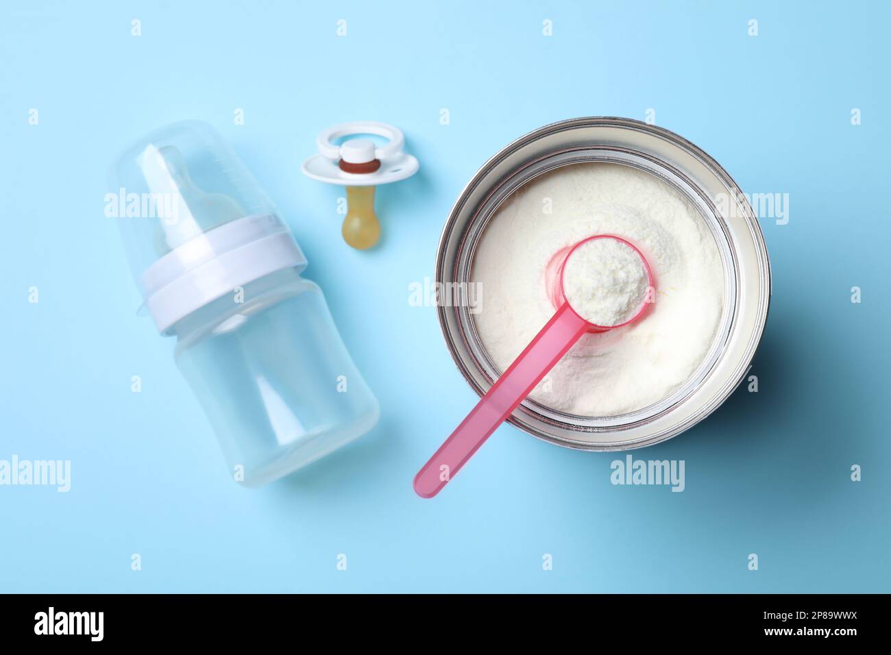 Flat lay composition with powdered infant formula on light blue ...