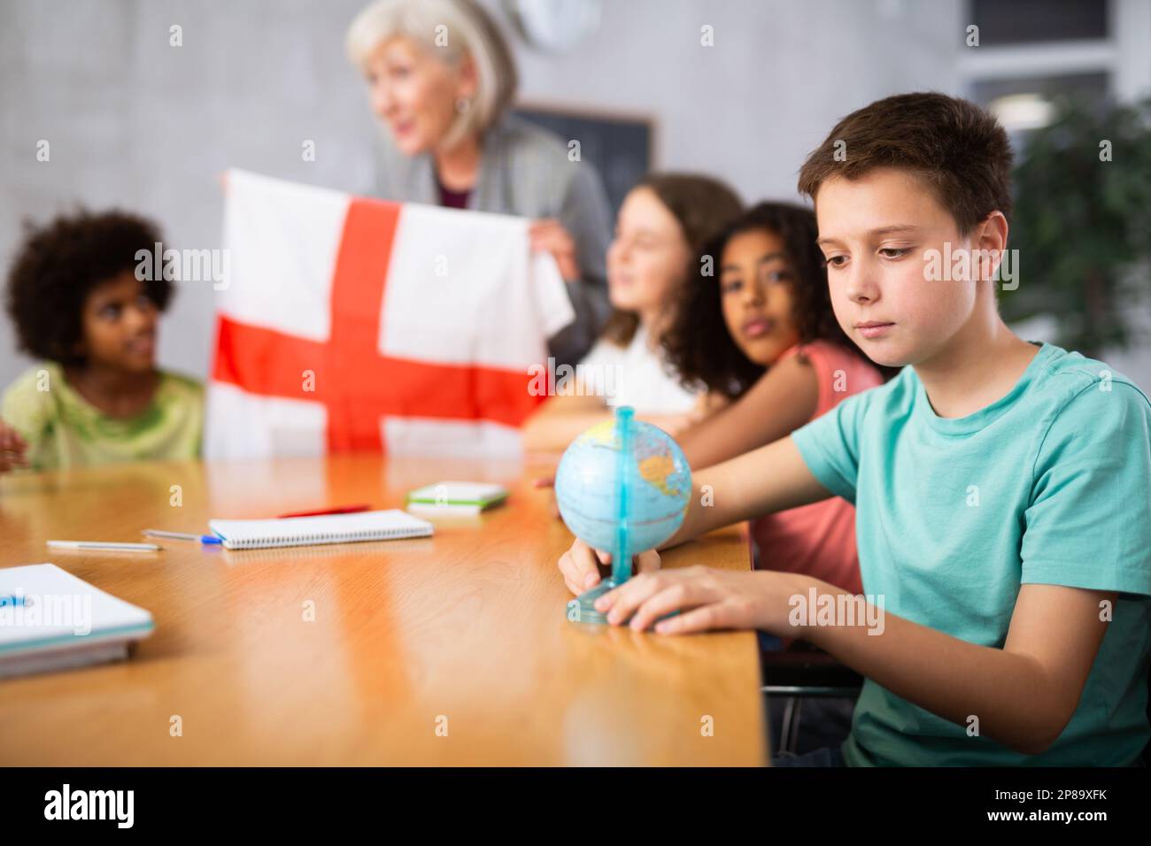 Female teacher showing english flag to kids in geography class Stock ...