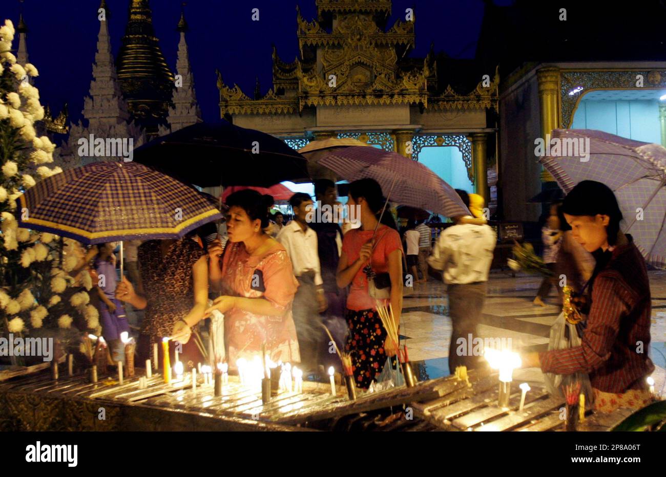 Buddhist devotees light the candles at Shwedagon Pagoda Monday, July 6 ...