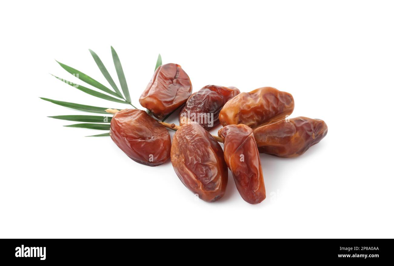 Sweet dates on branch and green leaves against white background. Dried ...