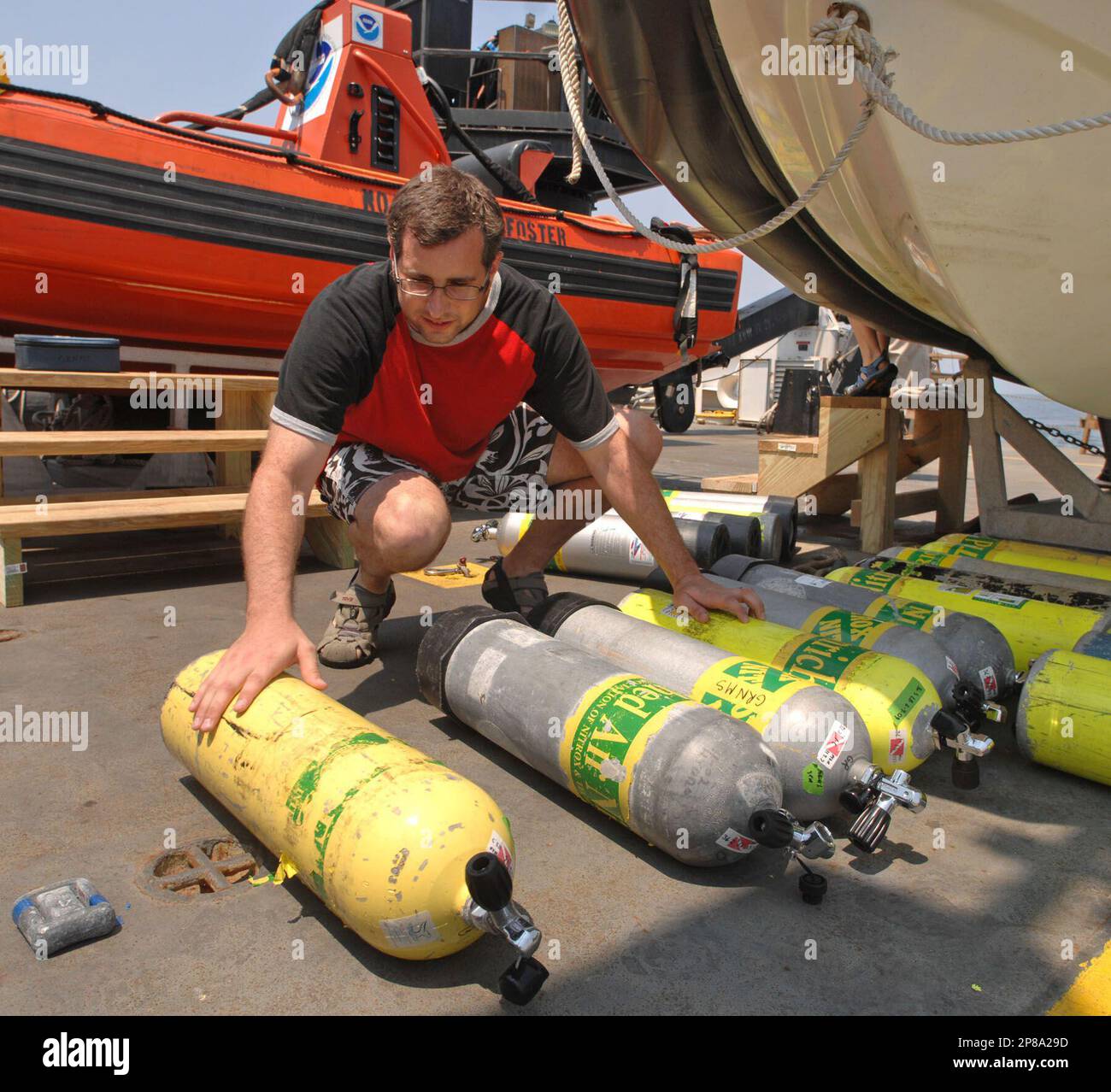 Team Ocean diver Jeff Hart assembles oxygen tanks aboard the NOAA ship ...