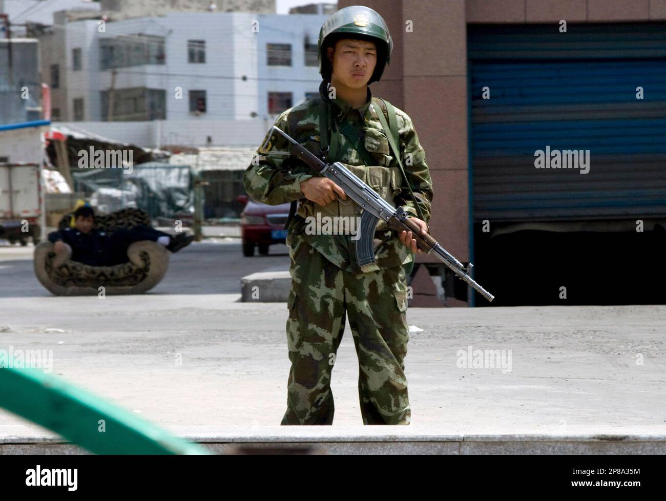 Chinese paramilitary police stand guard outside a market which was ...