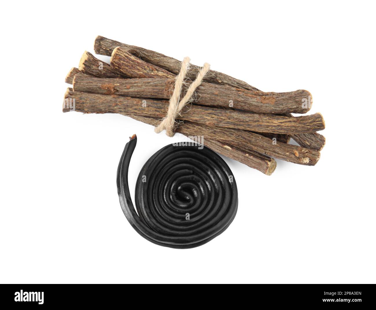 Tasty black candy and dried sticks of liquorice root on white ...
