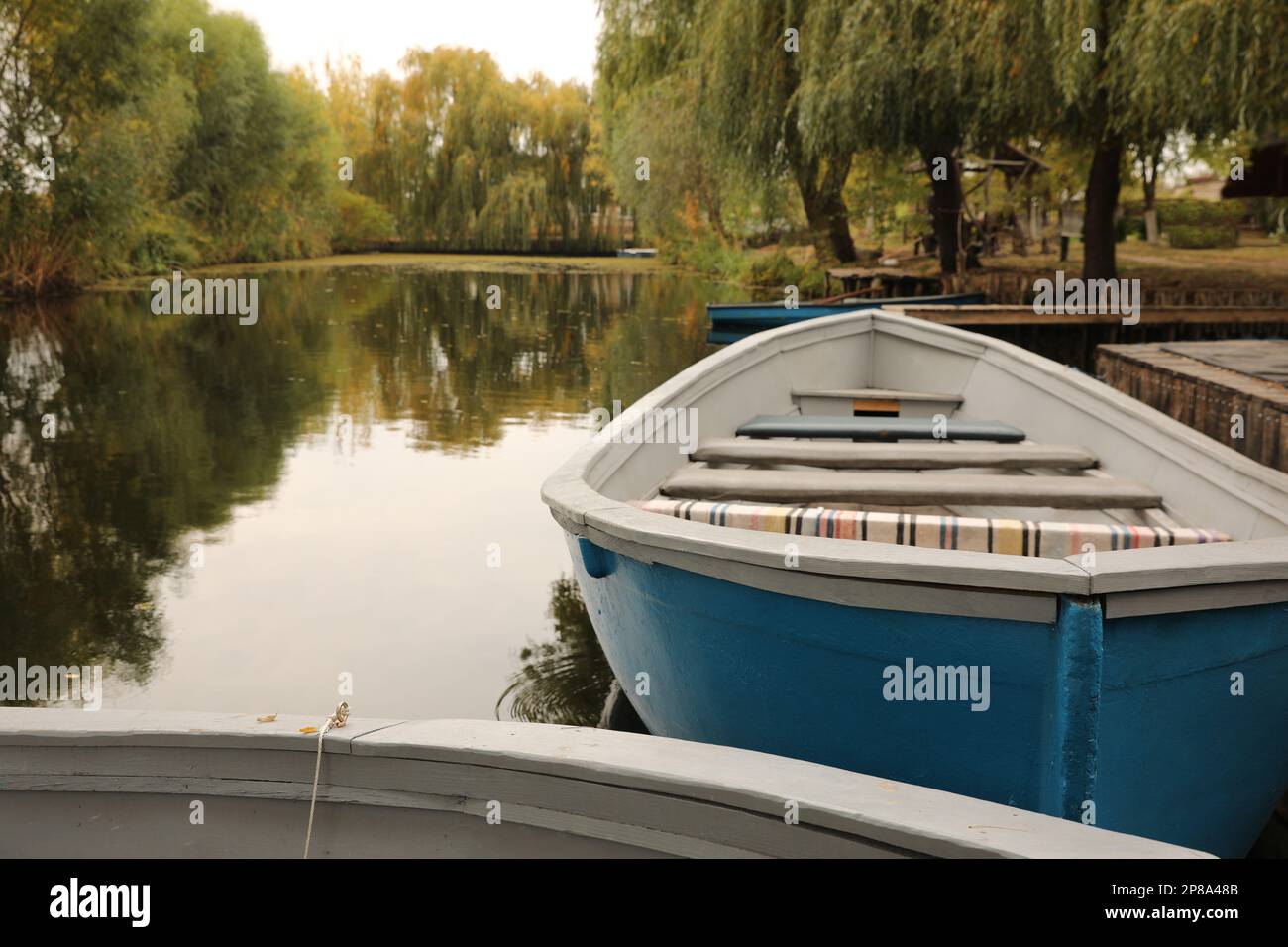 Light blue wooden boat on lake, space for text Stock Photo - Alamy