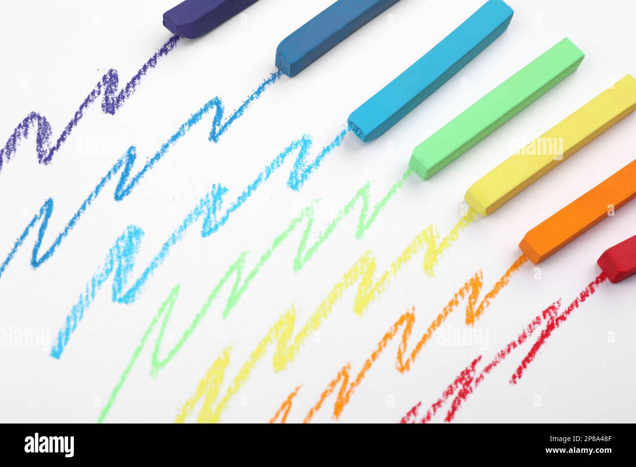 Colorful pastel chalks and scribbles on white background, above view ...