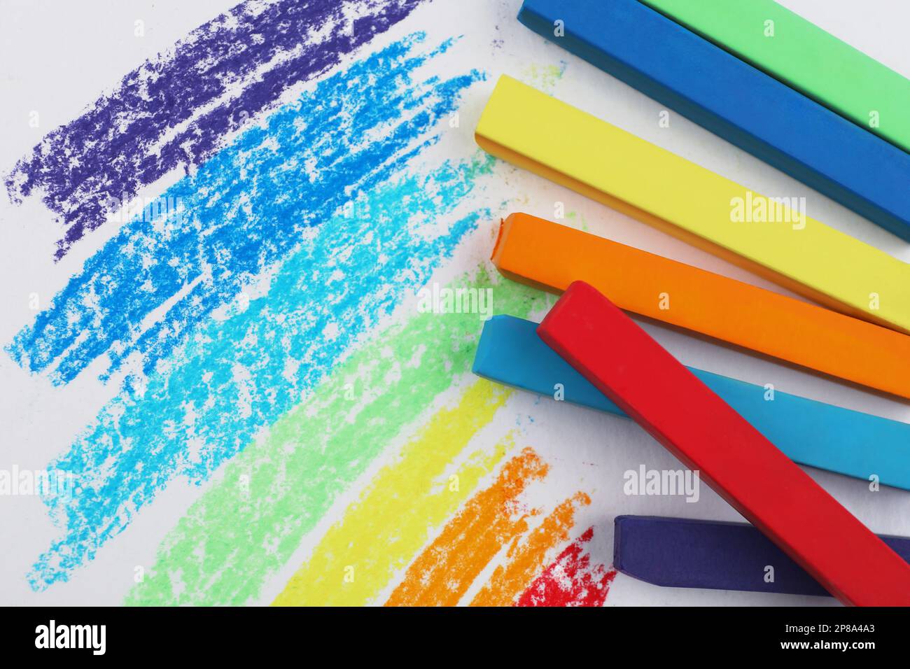 Colorful pastel chalks and scribbles on white background, flat lay ...