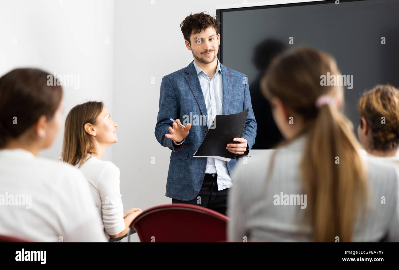 Young male teacher giving lecture to group of student Stock Photo - Alamy