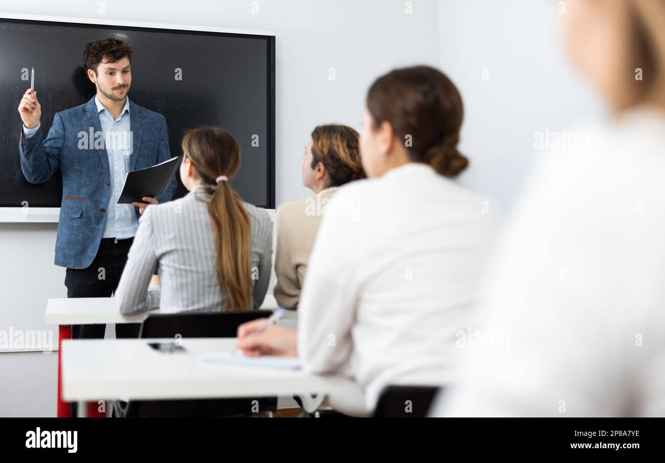 Positive male trainer, conducting advanced training courses to office ...