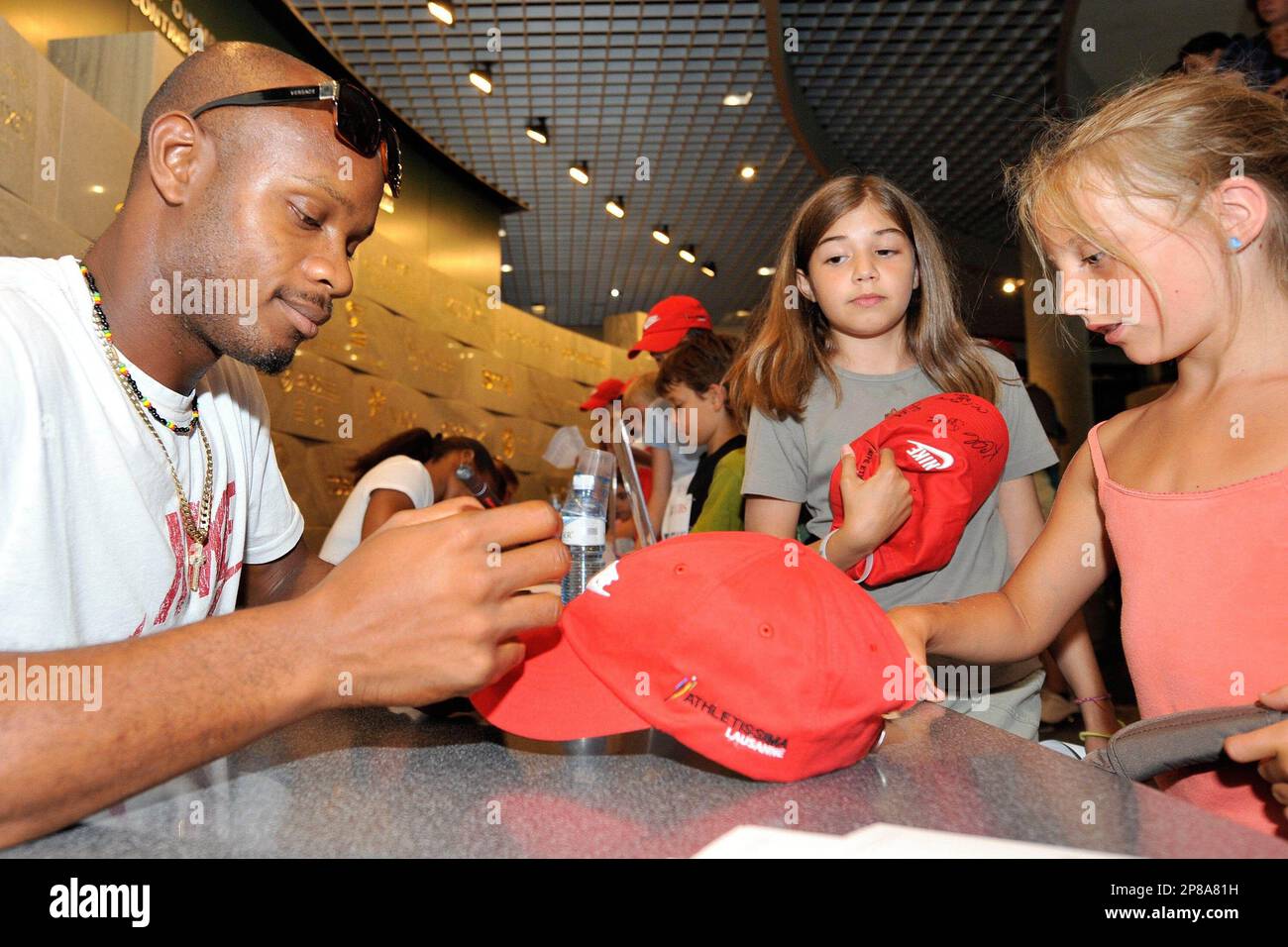 Jamaican sprinter Asafa Powell signs autographs at the Olympic museum ...
