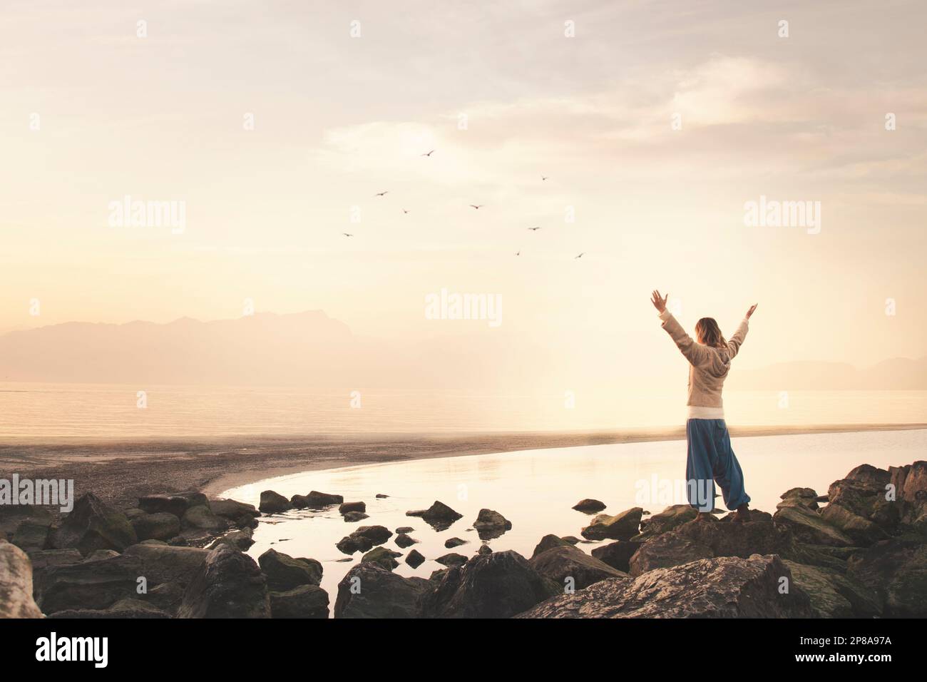 woman with arms outstretched takes a breath in front of a spectacular ...