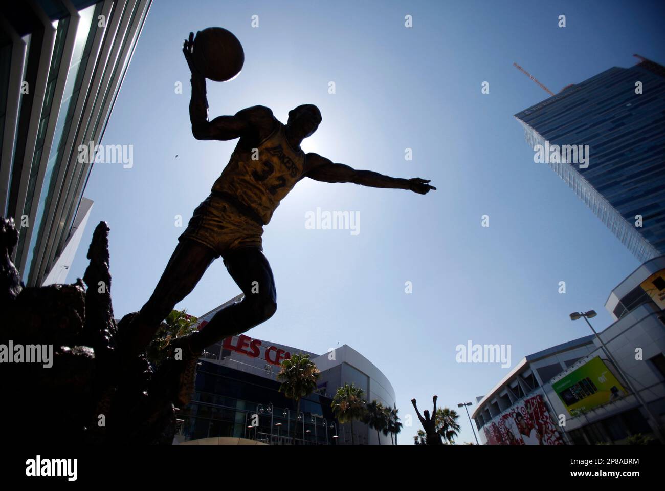 A bronze statue of Magic Johnson is silhouetted outside the Staples ...