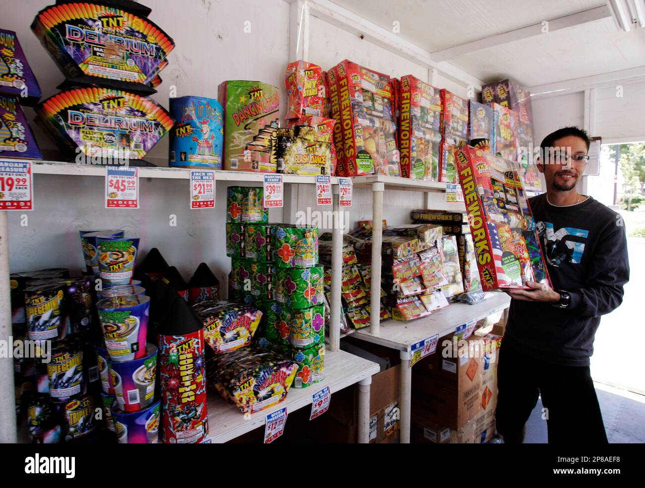 A salesman shows off fireworks to a customer at a fireworks booth in ...