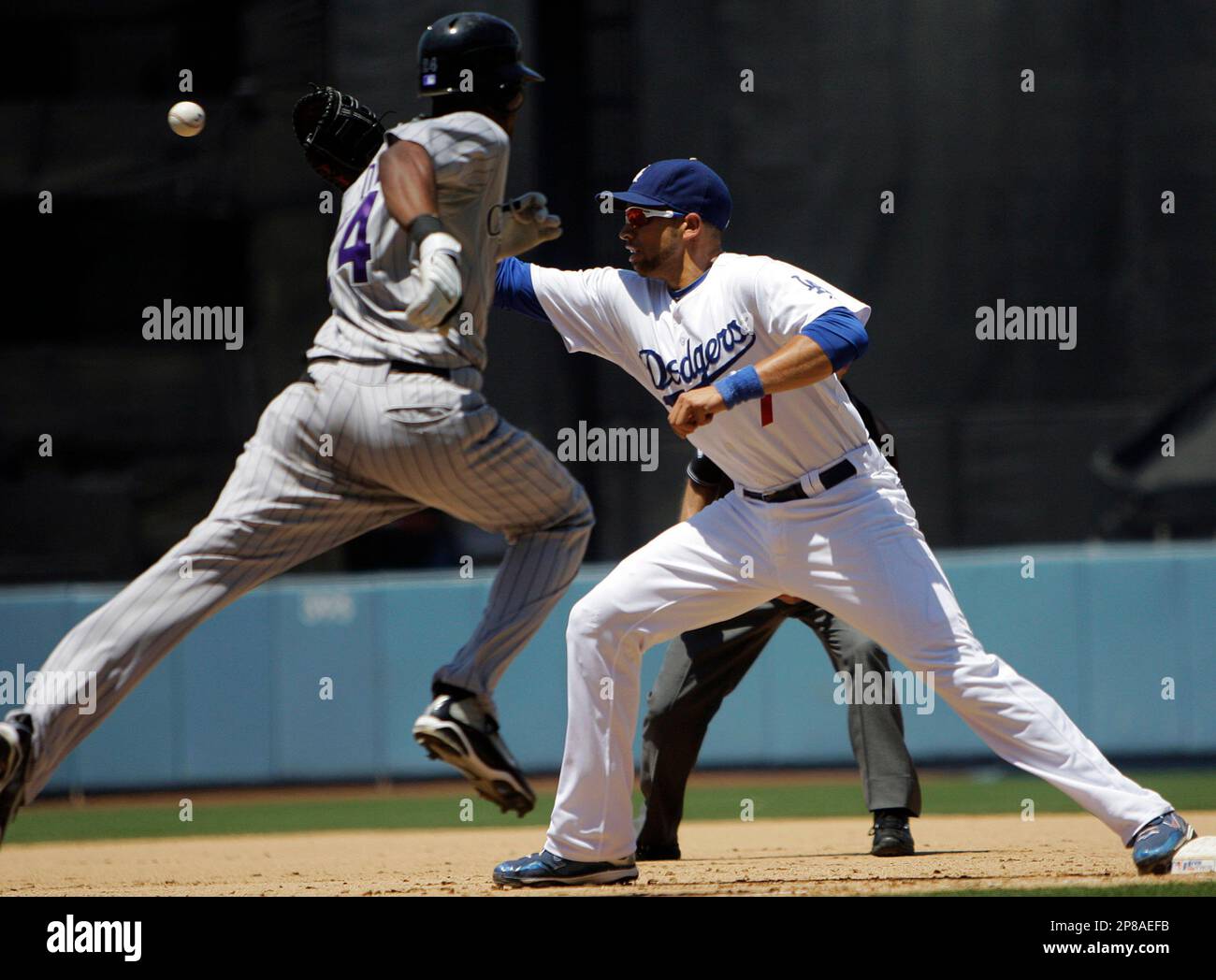 Colorado Rockies' Dexter Fowler, left, runs to first base as Los ...