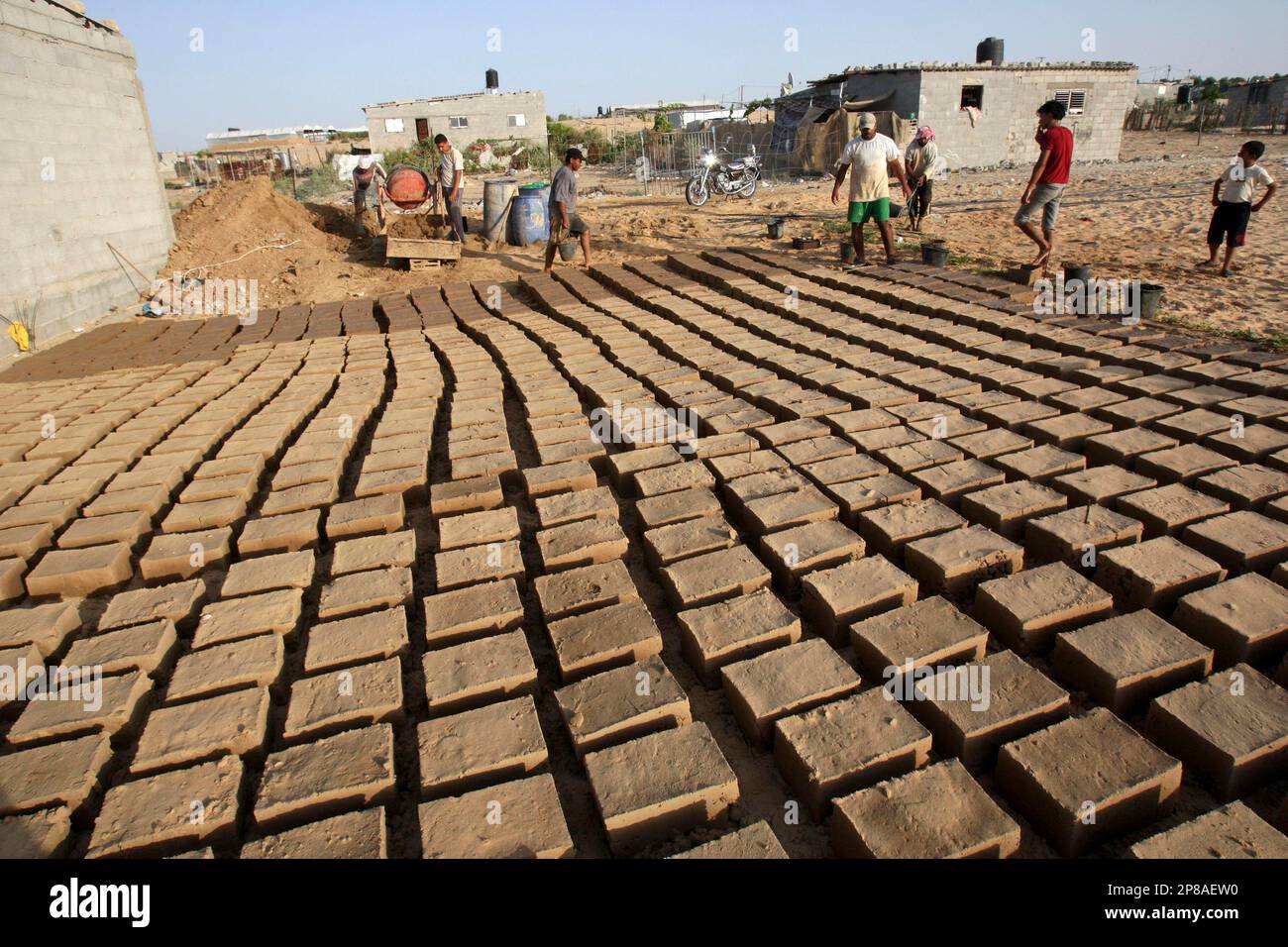 Palestinian workers prepare blocks of clay for the construction of clay ...