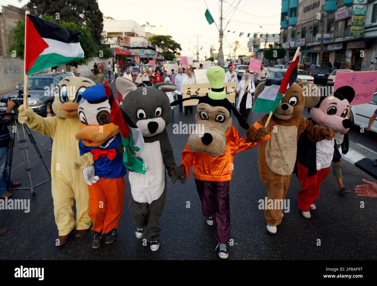Palestinians dressed up as Disney characters march during a ...