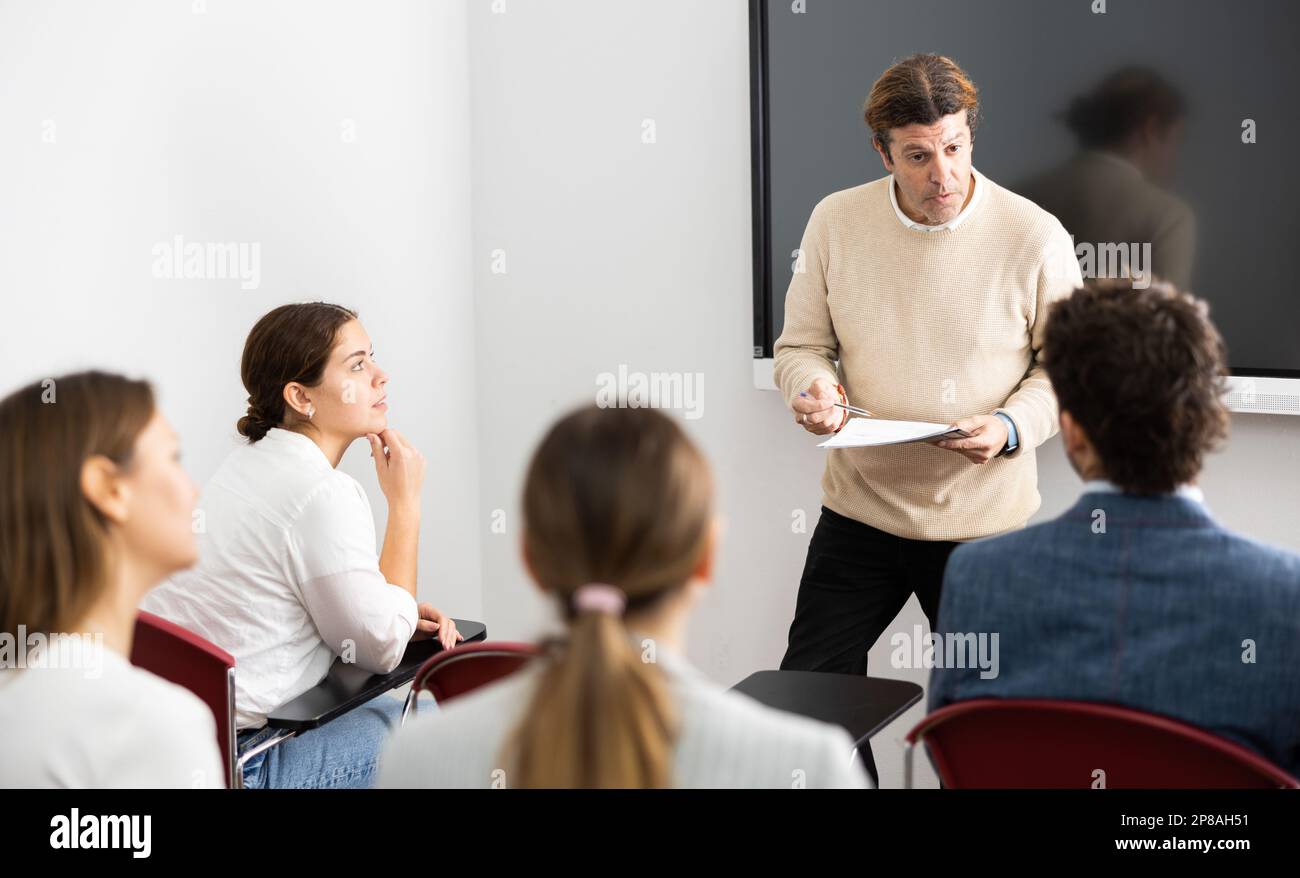 Knowledgeable professor explaining subject to classroom full of ...