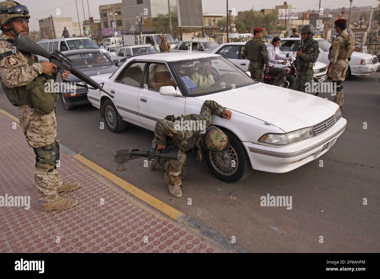 Iraqi soldiers check a car at an army checkpoint in Basra, Iraq's ...
