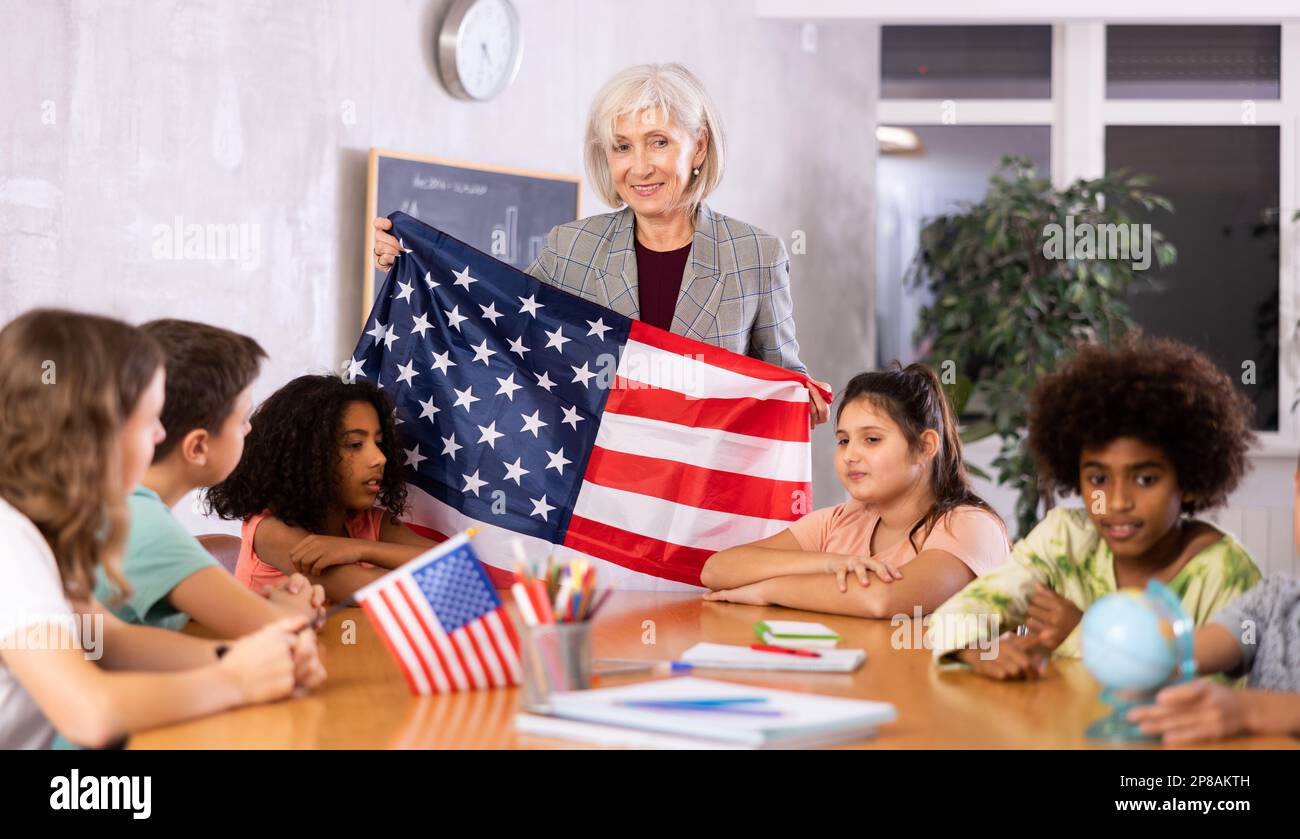 Friendly female teacher tells the pupils the history of the USA Stock ...