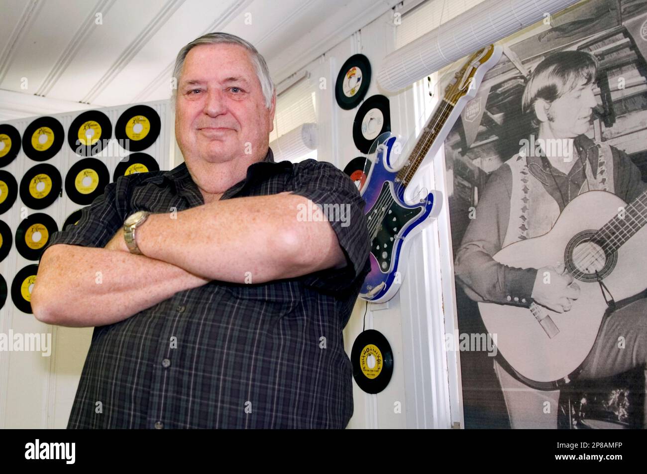 Fred Powell poses with a poster of a young looking Willie Nelson in his ...
