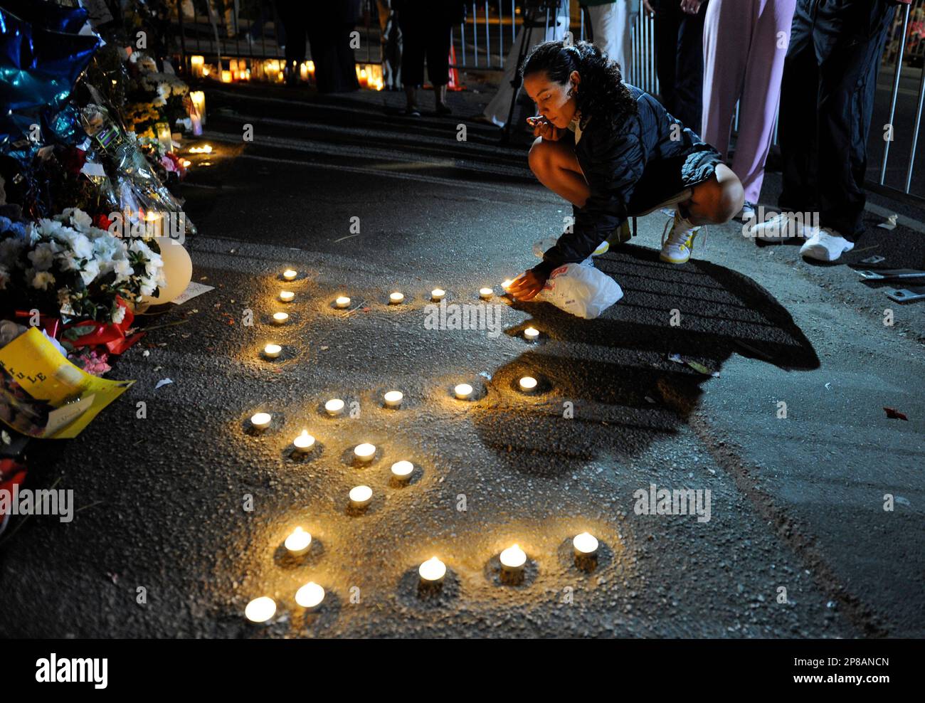 Kena Patterson, of Los Angeles, writes out "MJ" with lit candles at a ...