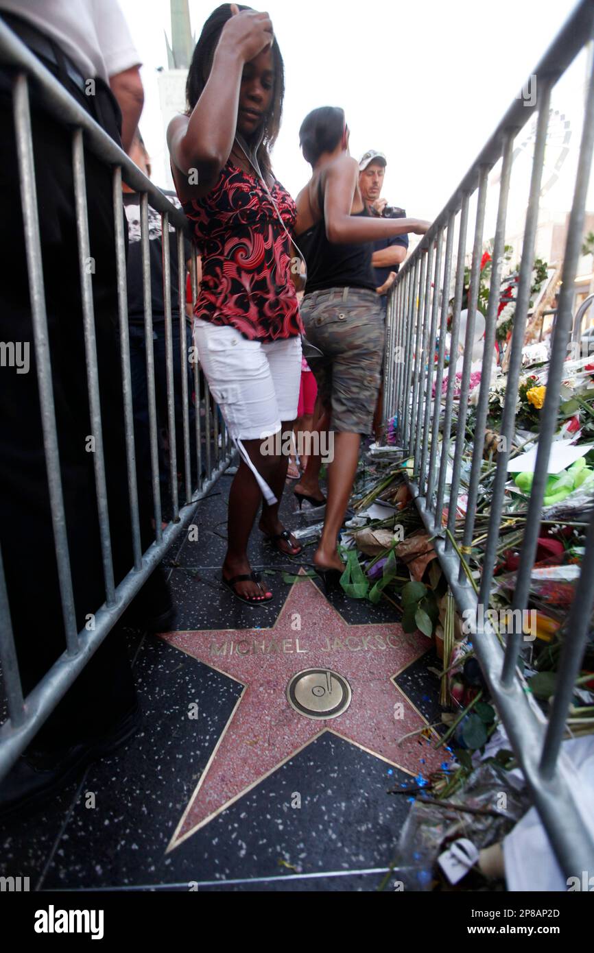 Juliet Musoke, left, and her sister Mary squeeze between fences erected ...