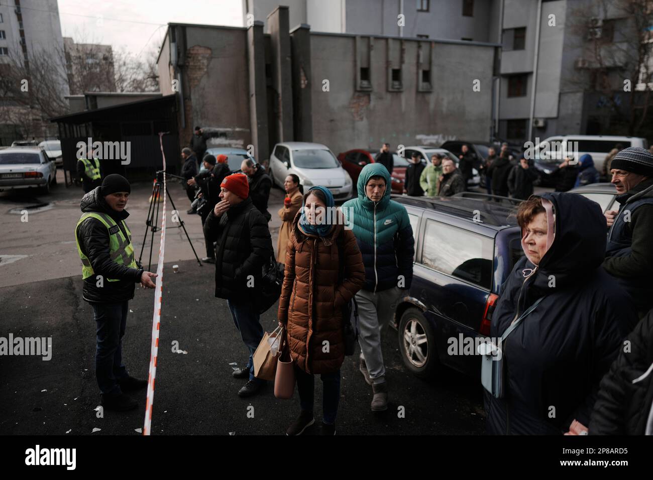 People wait behind police cordon after a rocket attack in Kyiv, Ukraine ...