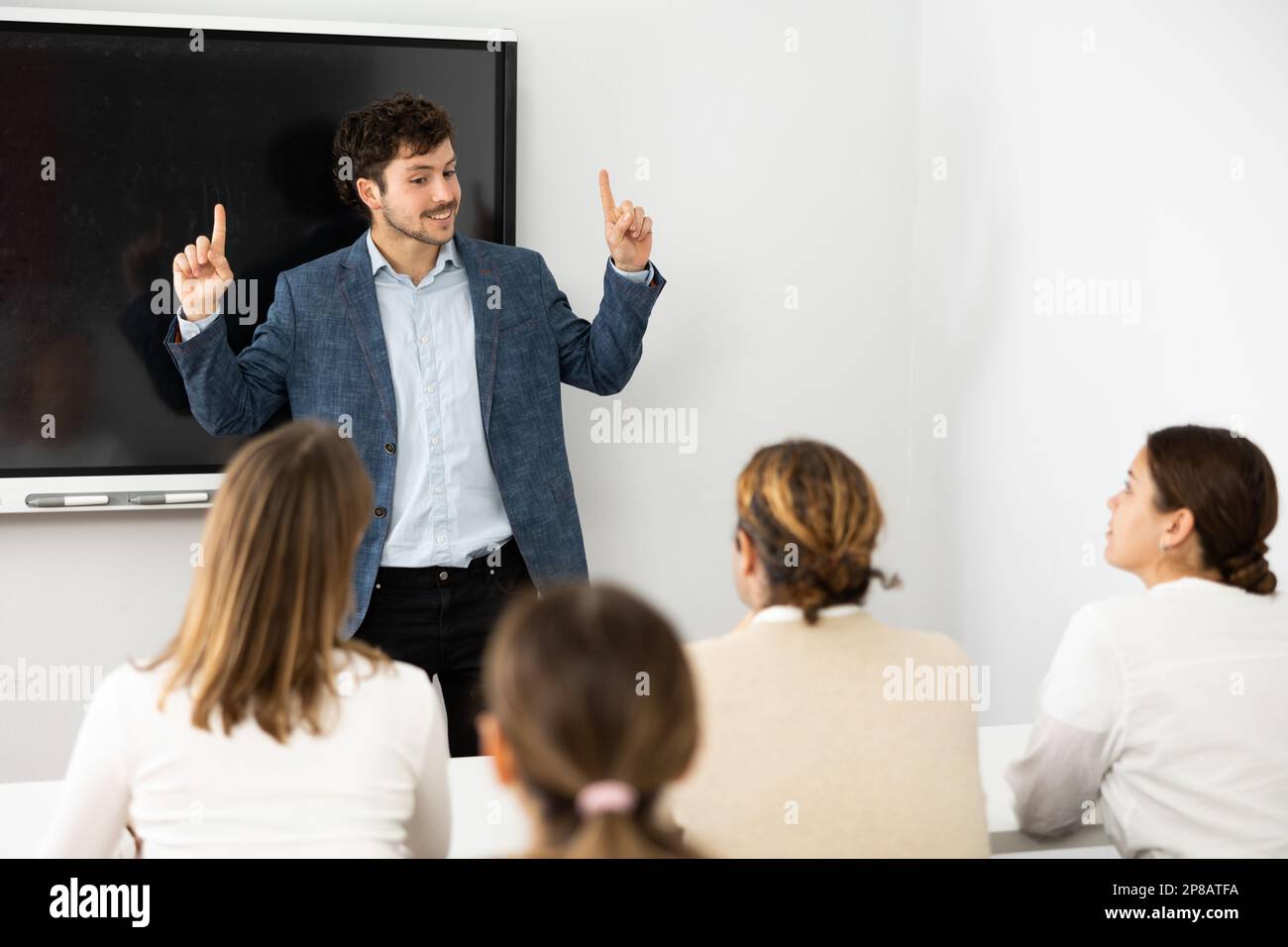 Young male tutor teaching students in college classroom Stock Photo - Alamy