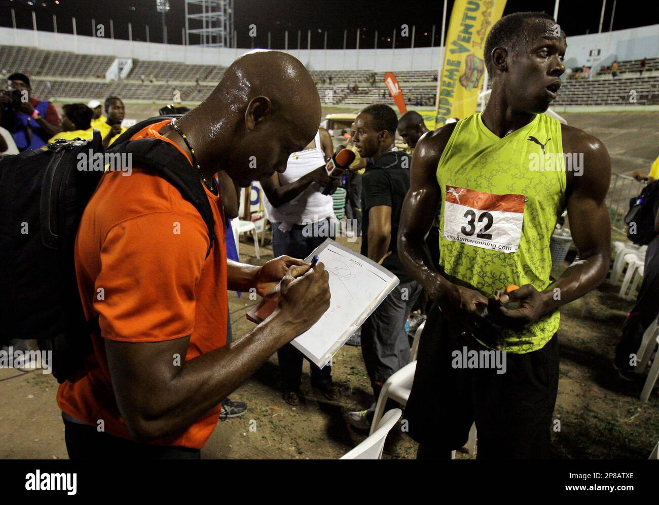Olympic sprint double champion Usain Bolt of Jamaica, right, looks at ...