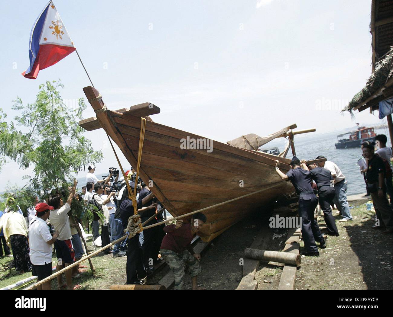 Filipino coastguard personnel and workers push a replica of the ...