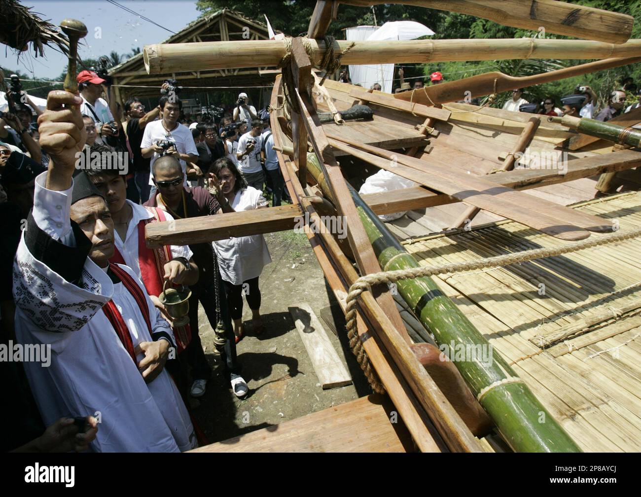 A Filipino Catholic priest performs blessing rites on a replica of the ...