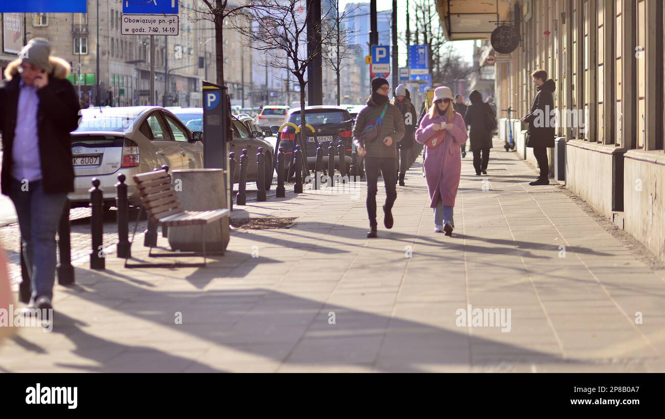 Warsaw, Poland. 8 March 2023. Crowd of people walking down an urban ...