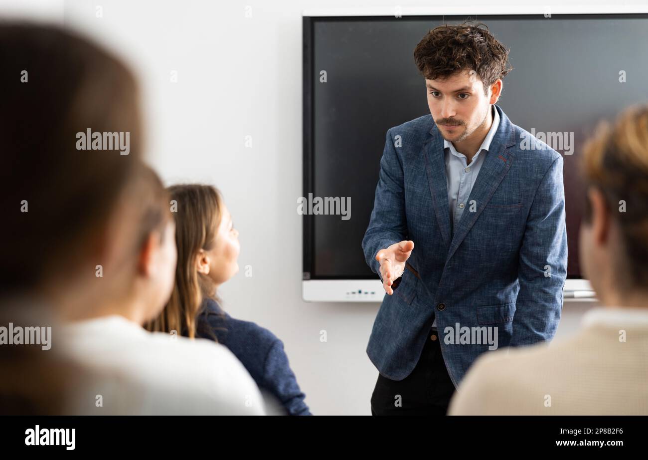 Young male teacher giving lecture to group of student Stock Photo - Alamy