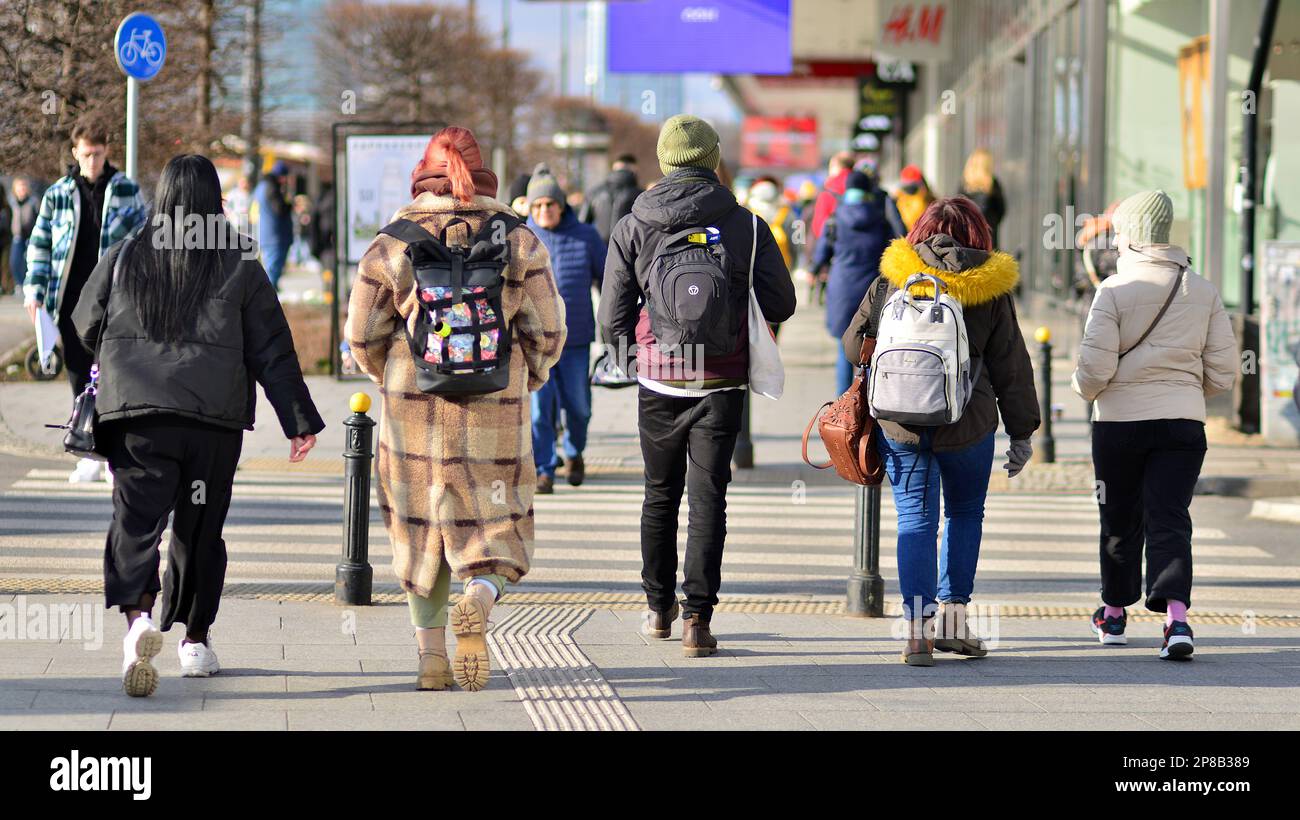 Warsaw, Poland. 8 March 2023. Crowd of people walking down an urban ...