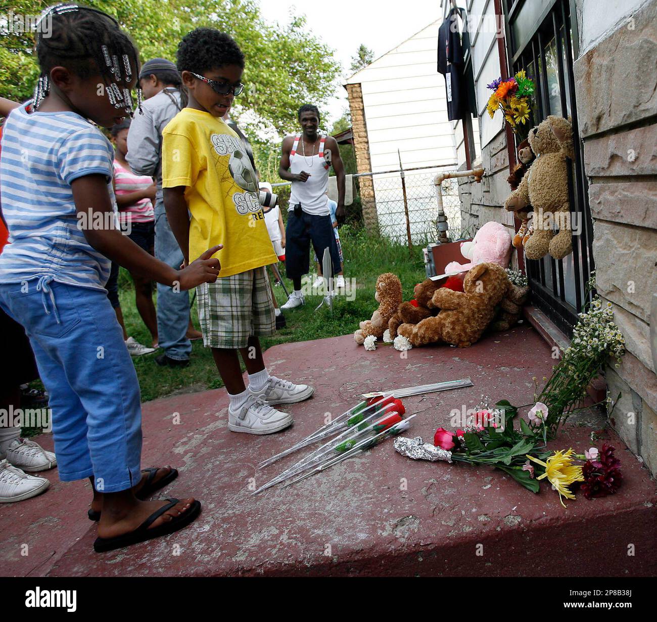 Nehemiah Williams 5, second from left, looks at the flowers and teddy ...
