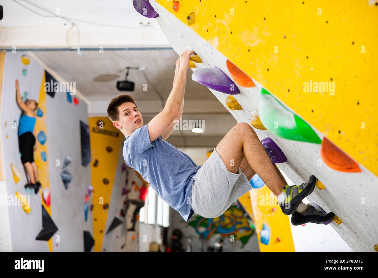 Male mountaineer climbing artificial rock wall without his belay ...