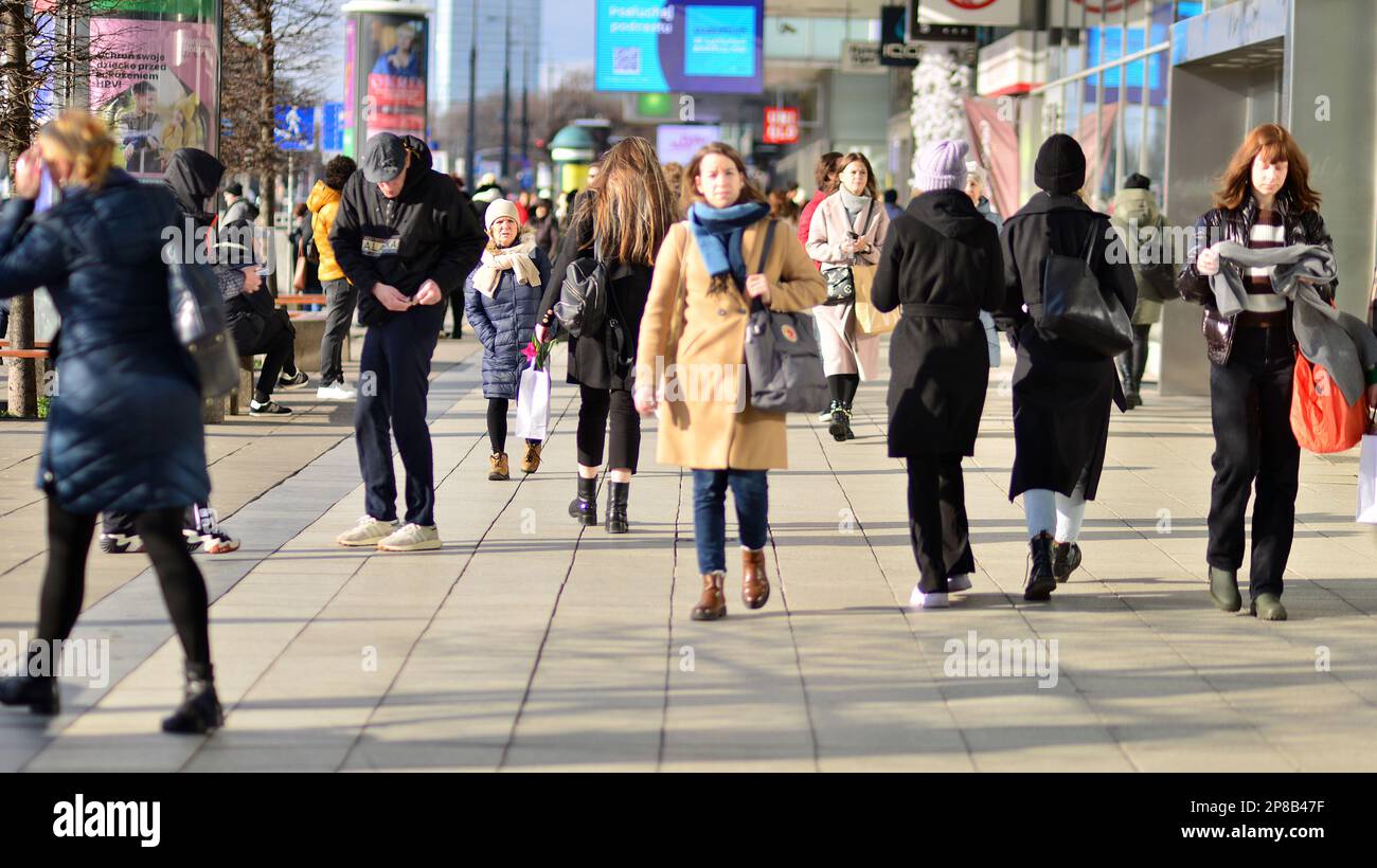 Warsaw, Poland. 8 March 2023. Crowd of people walking down an urban ...