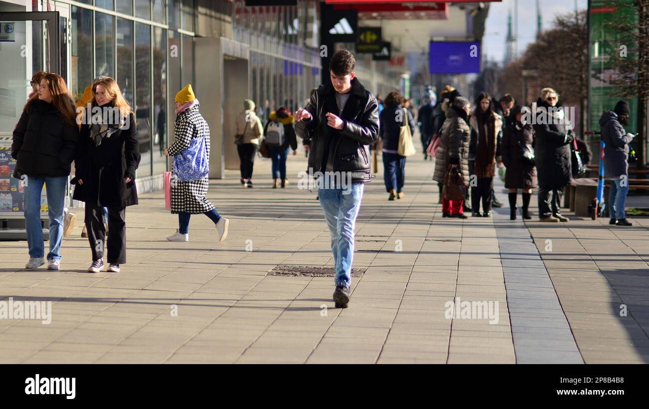 Warsaw, Poland. 8 March 2023. Crowd of people walking down an urban ...
