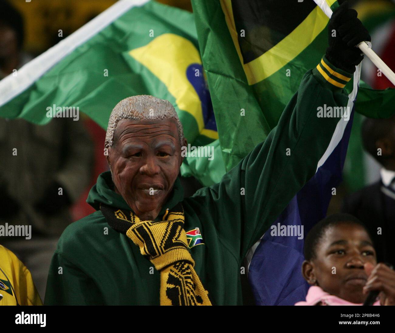A supporter of the South African soccer team wears a mask depicting ...