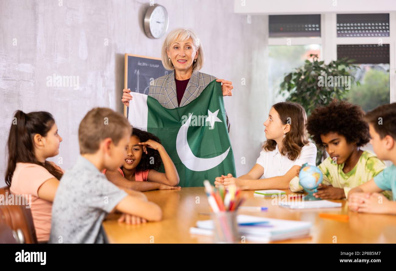Female teacher showing pakistani flag to kids in geography class Stock ...