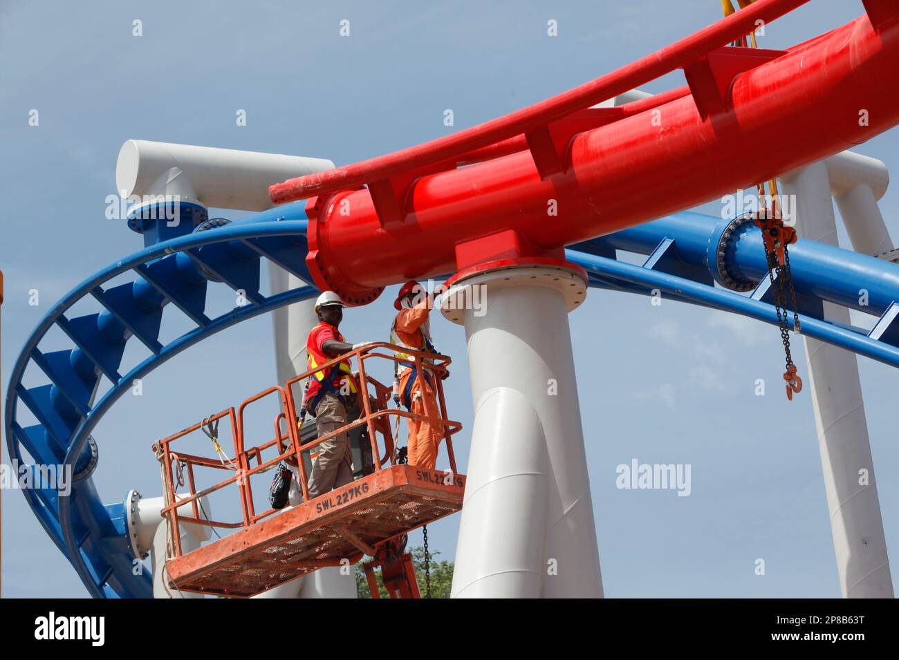 Workers piece together a duelling roller coaster track at the ...