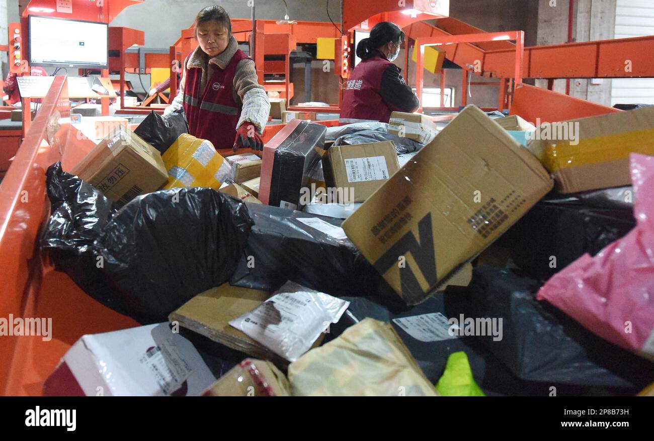 Female workers sort express packages on the assembly line in the e ...