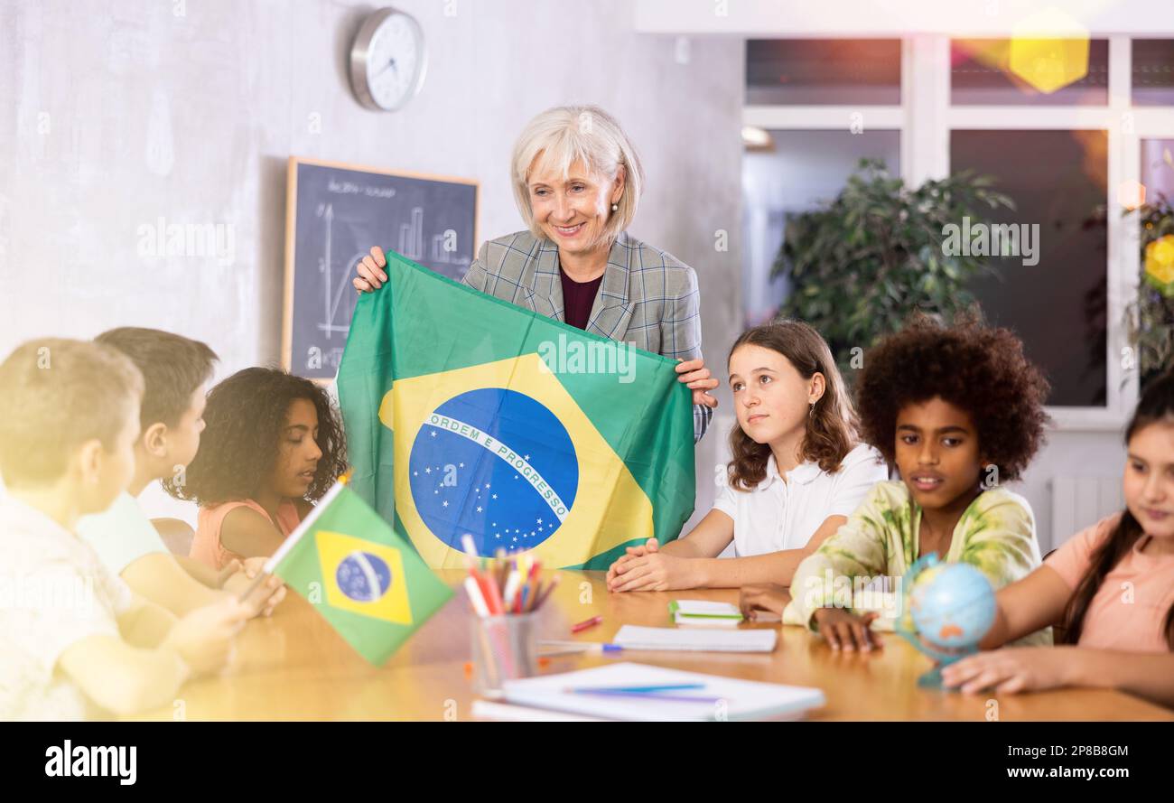 Female teacher showing brazilian flag to kids in geography class Stock ...
