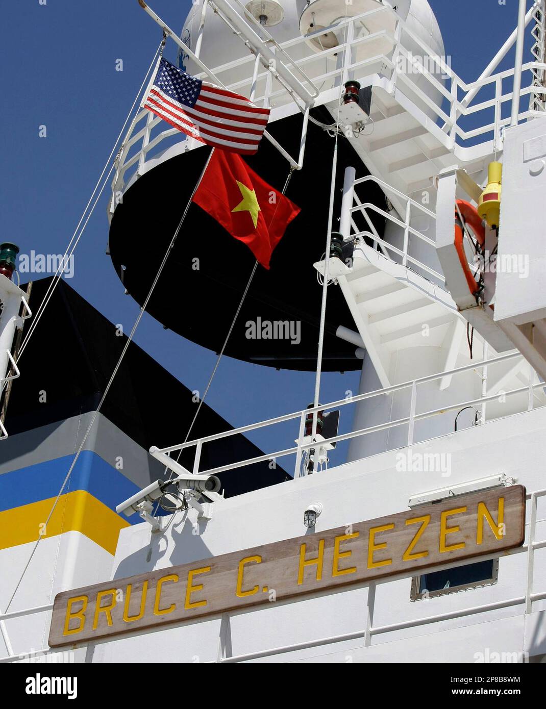 U.S. and Vietnam flags fly together on the USNS Bruce C. Heezen, an ...
