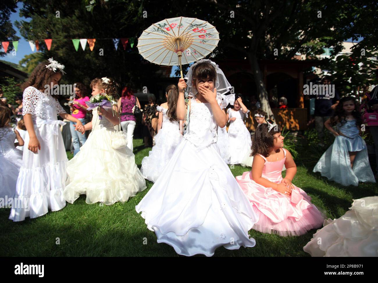 Girls dressed in wedding dress attend during the celebrations of the ...