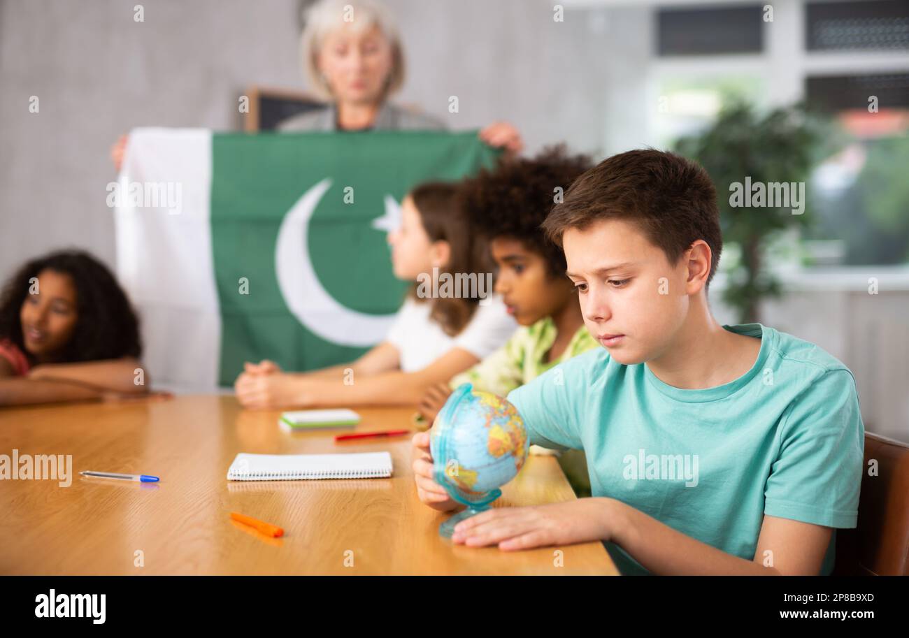 Mature woman teacher tells the pupils the history of Pakistan Stock ...